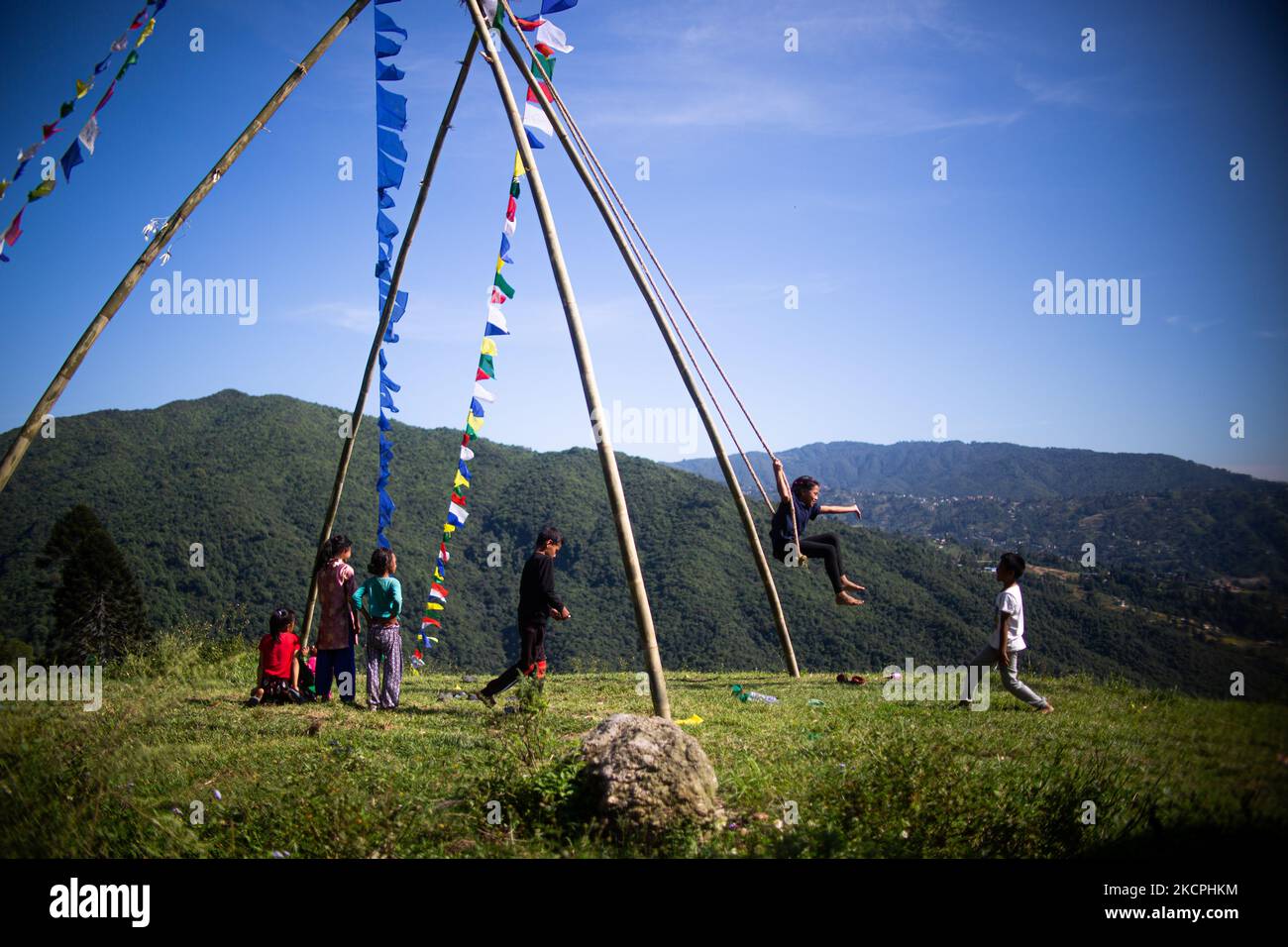 Nepalese kids ride a traditional swing set up as part Dashain festival ...