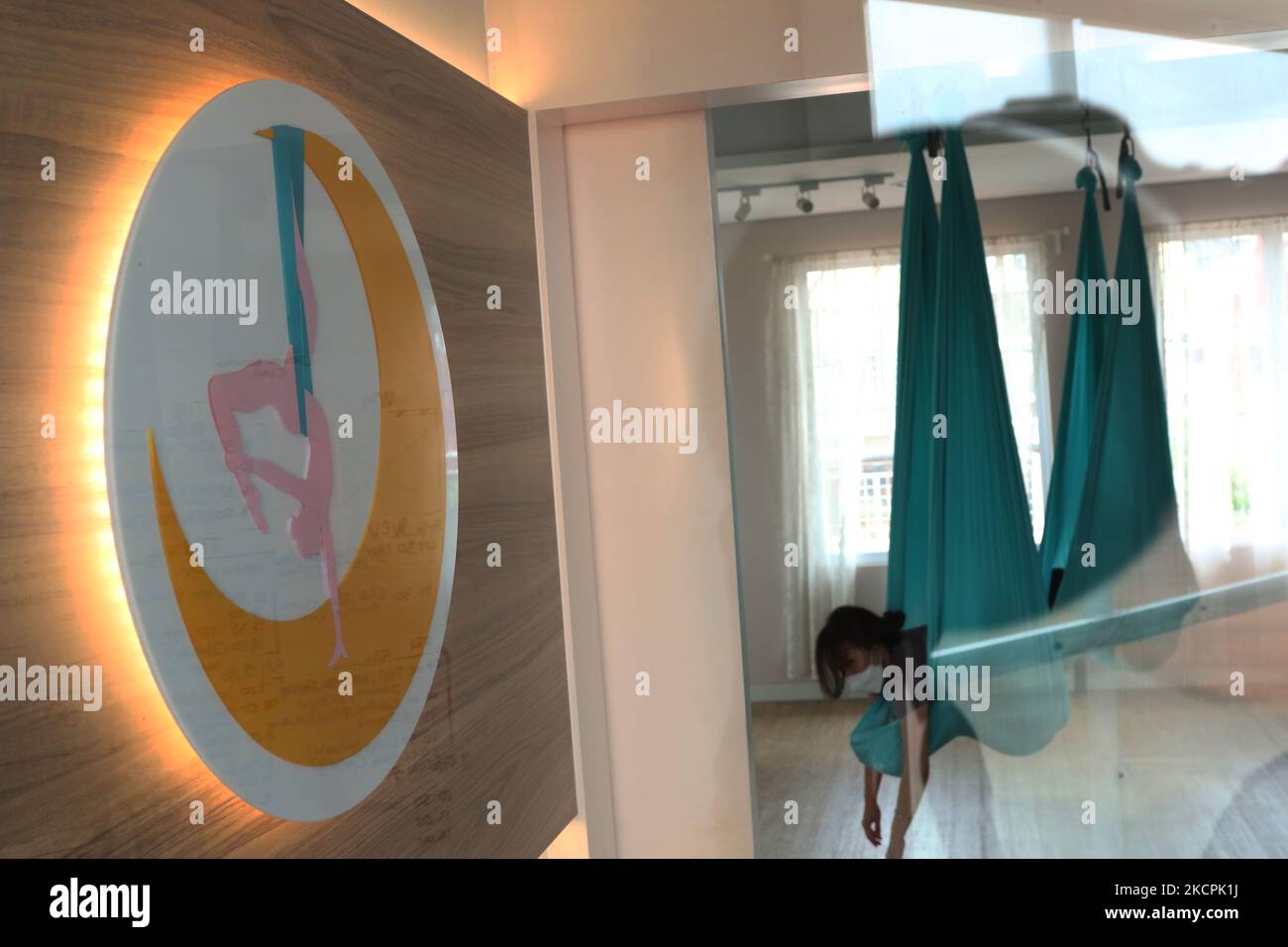 Women take an aerial yoga class at Aerial Jooga Studio using masks and ...