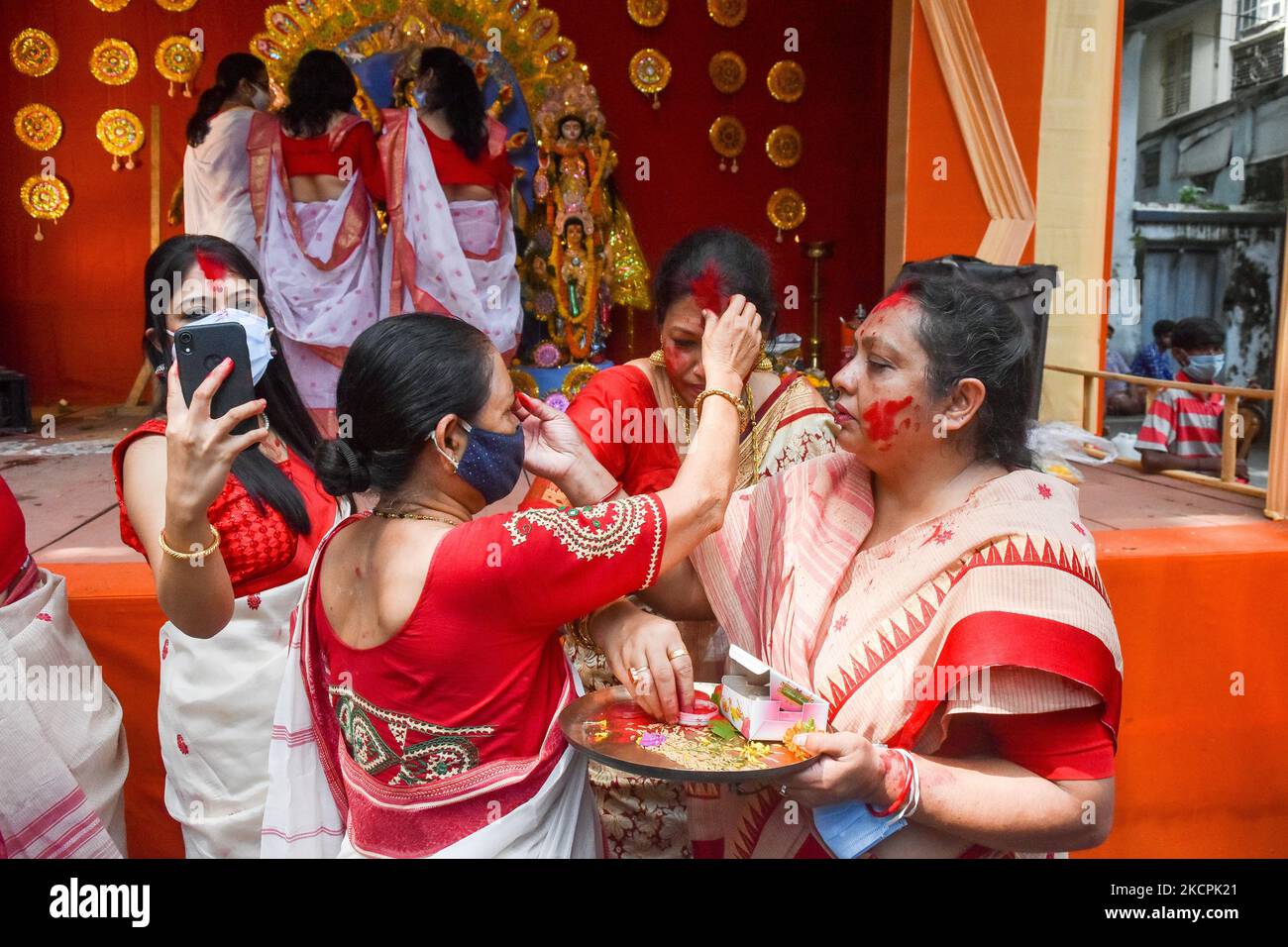 Married ladies smearing red sindur or vermilion , a ritual known as ...