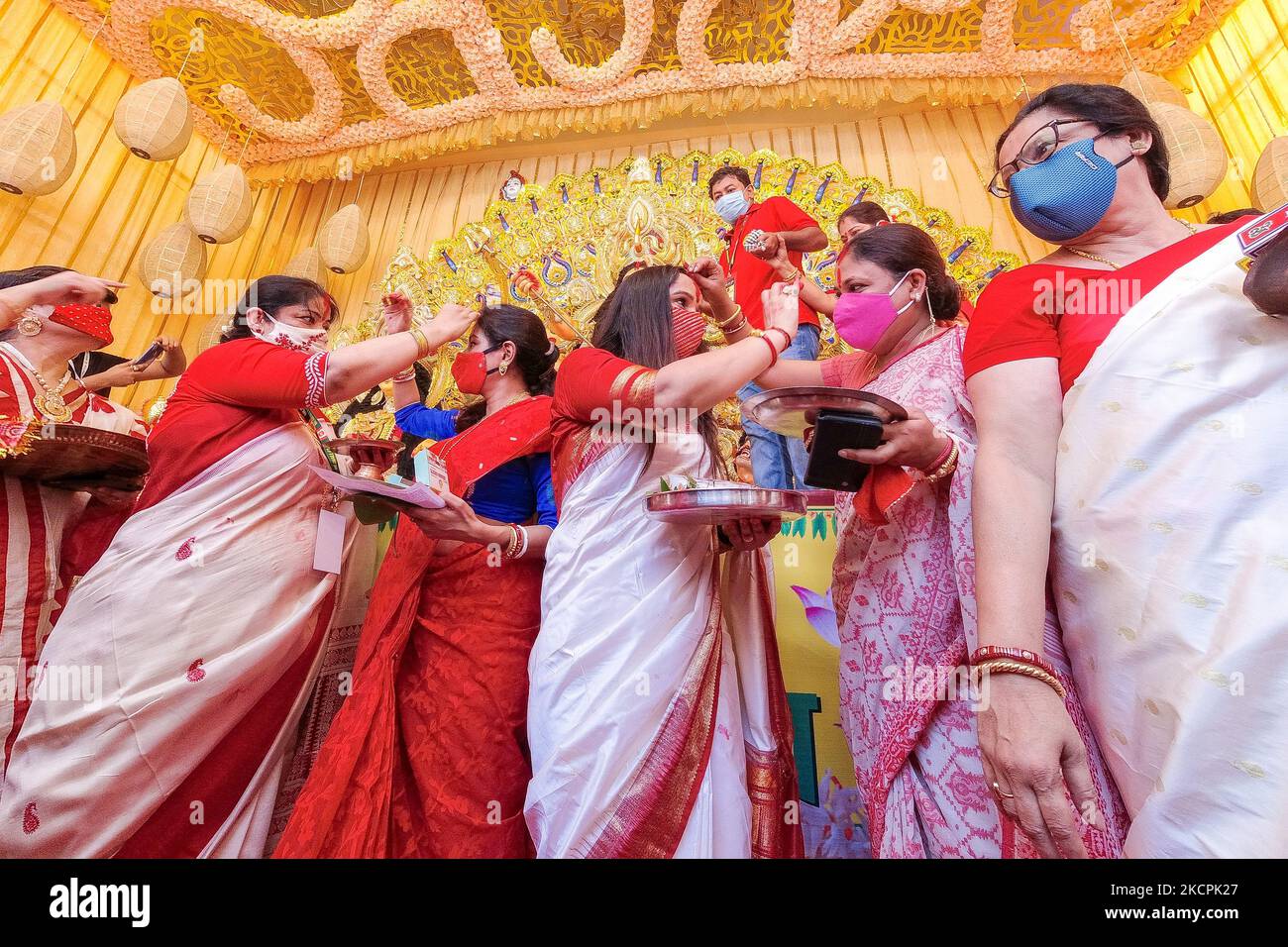 Married ladies smearing red sindur or vermilion , a ritual known as ...