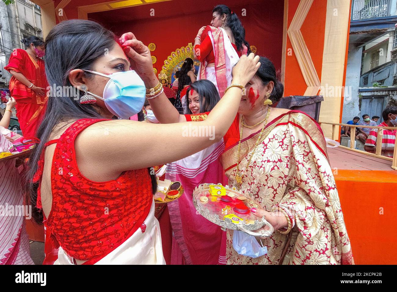 Married ladies smearing red sindur or vermilion , a ritual known as ...