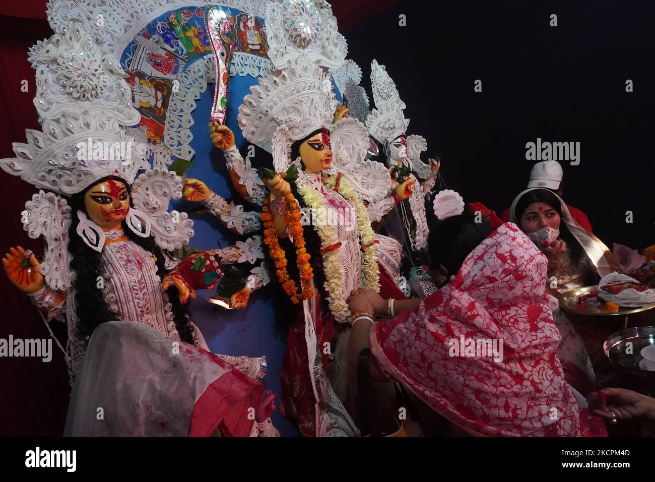 Hindu women devotees perform rituals in front of an idol of goddess ...