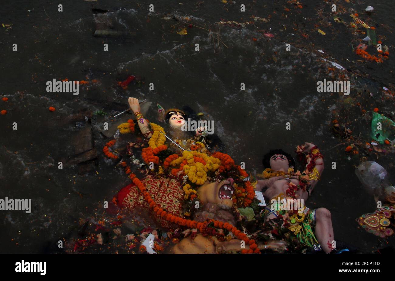 Goddess Durga's idol is seen before sinking into the water after ...
