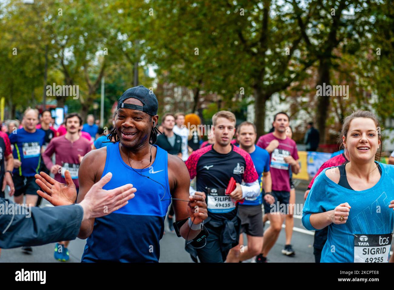 A runner is giving high five to a man watching the run, during the TCS ...