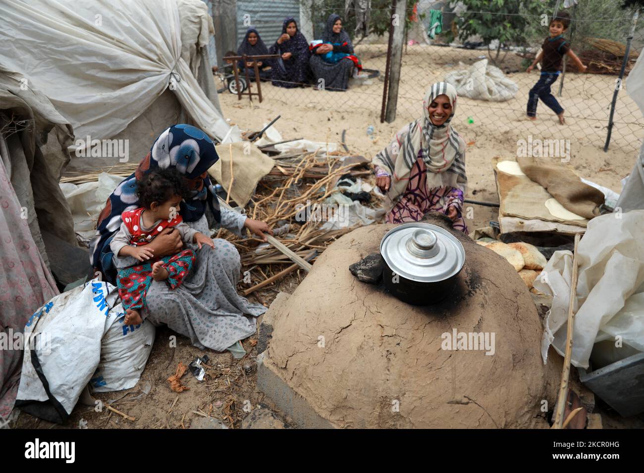 Palestinian women bake traditional bread using a clay oven in Khan ...
