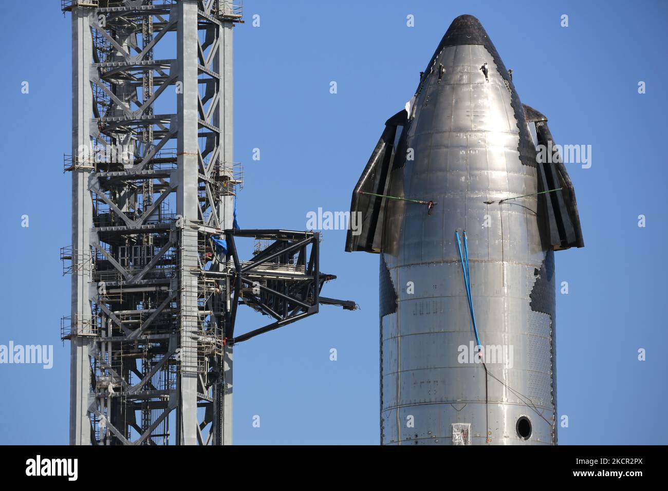 The Starship launch tower is seen with one of its arms connected behind ...