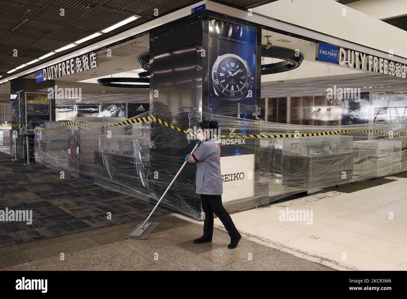 Workers clean a floor storefront a duty free shop during a media ...