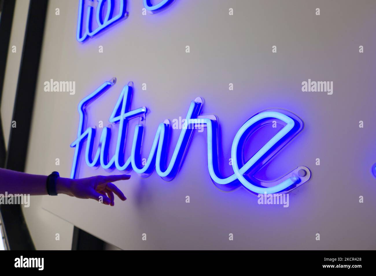 Blue neon signs FUTURE BEGINS HERE in English and Arabic on wall . High ...