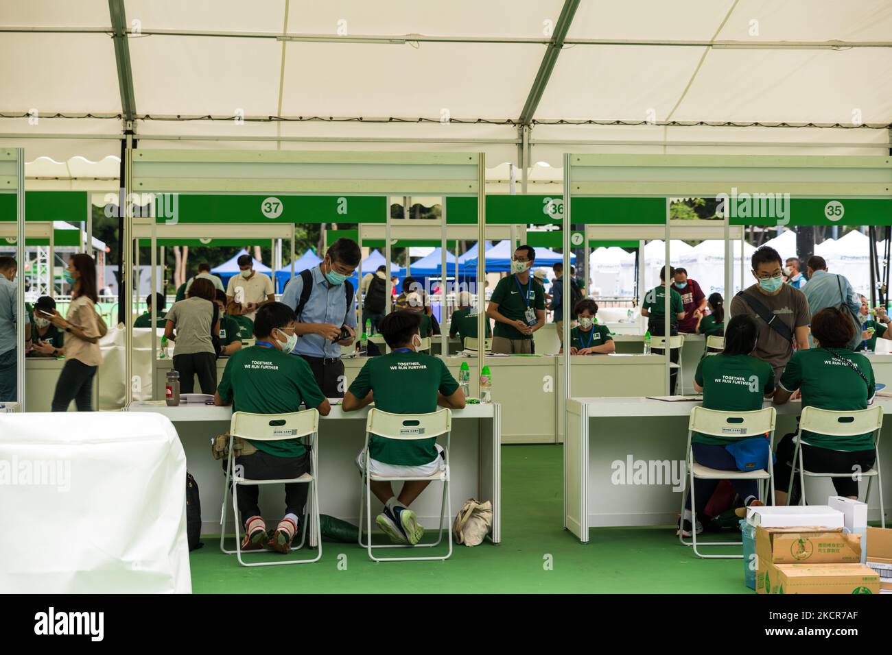 Runners show their ID cards and vaccination records at registration ...