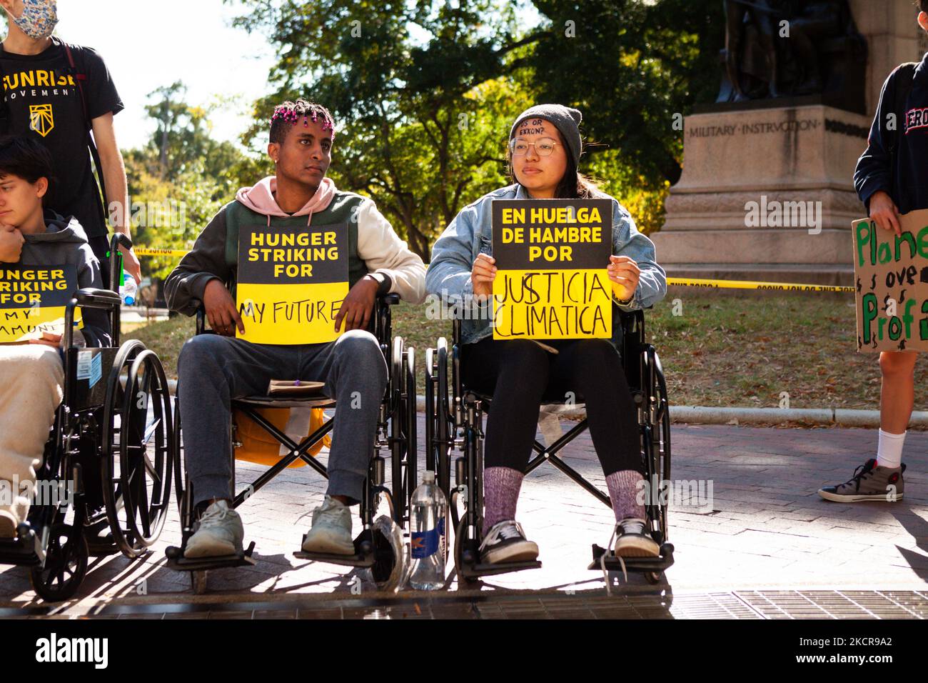 Hunger strikers hold signs with the reason(s) they are striking at a ...