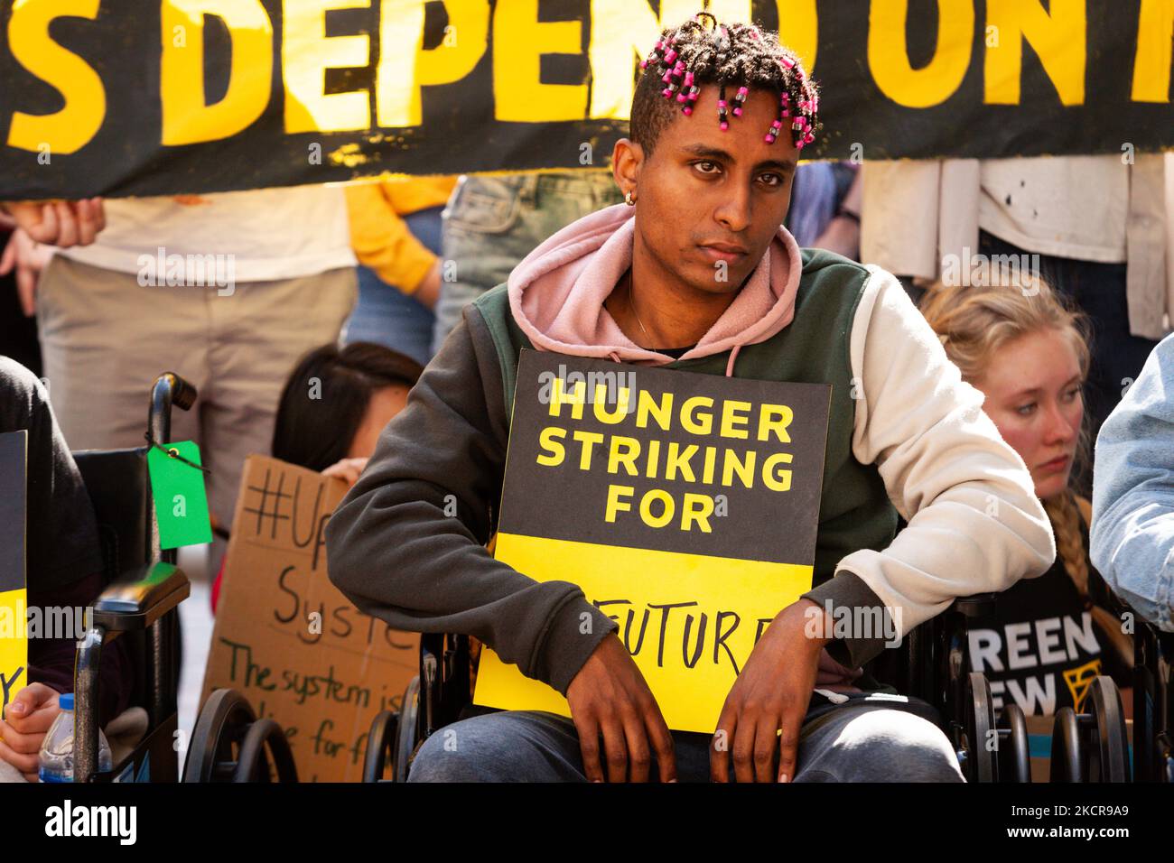 Hunger strikers hold signs with the reason(s) they are striking at a ...