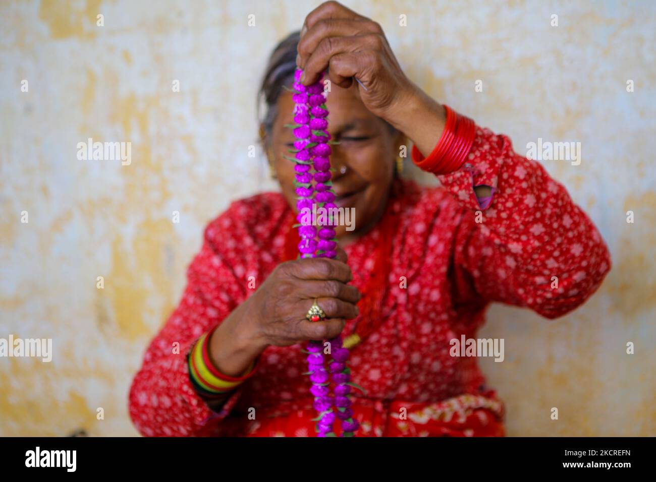 A woman makes garland from the globe amaranth flowers for the upcoming ...