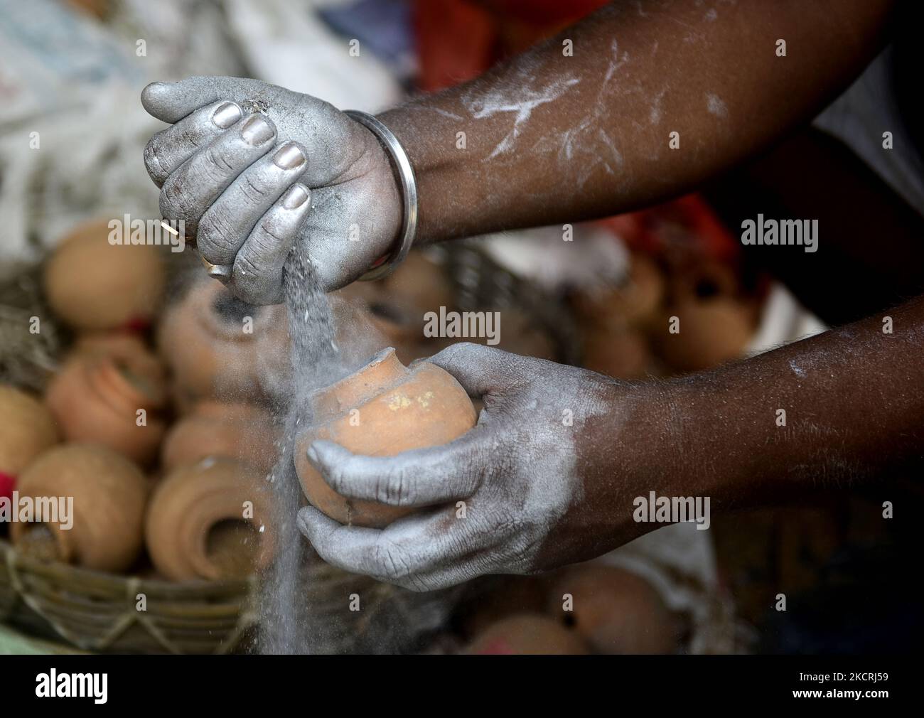 Indian worker puts gun powder inside a clay pot to make a firecracker ...