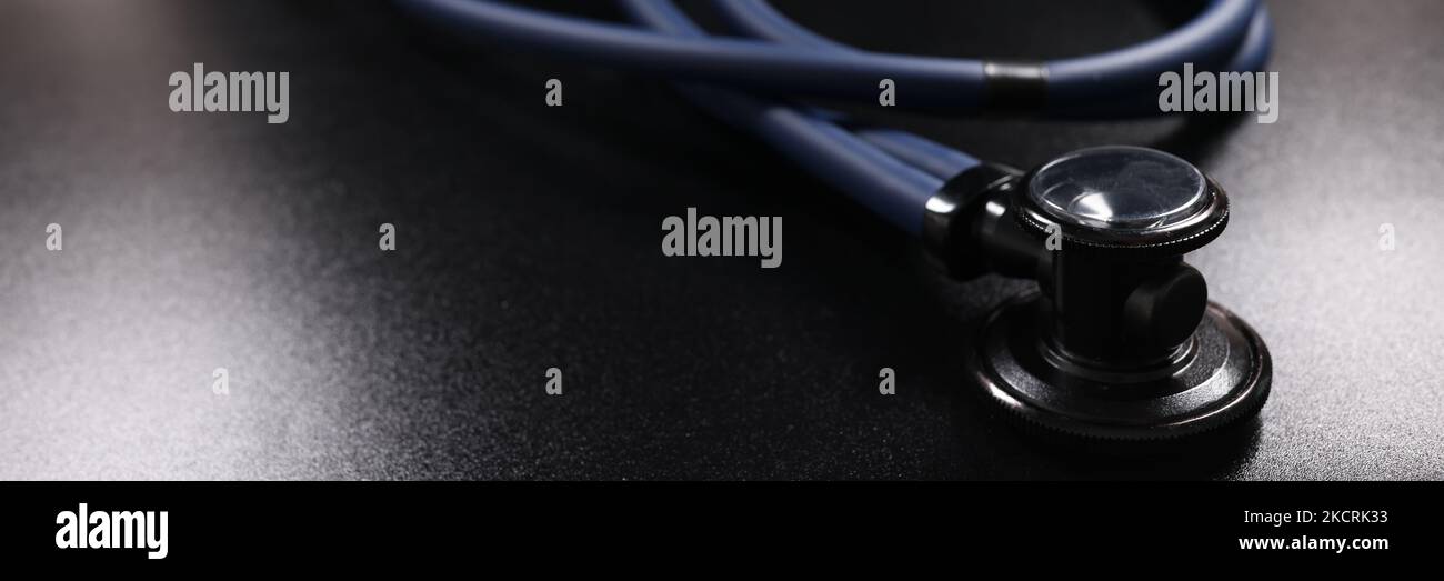 Dark blue medical stethoscope on black surface Stock Photo - Alamy