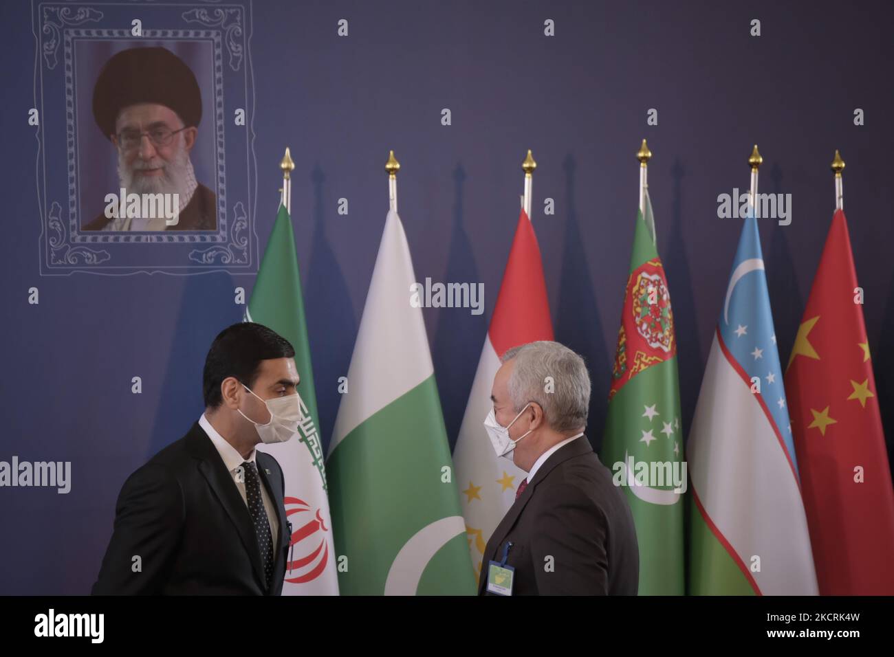 Two unidentified diplomats wearing protective face masks speak with ...