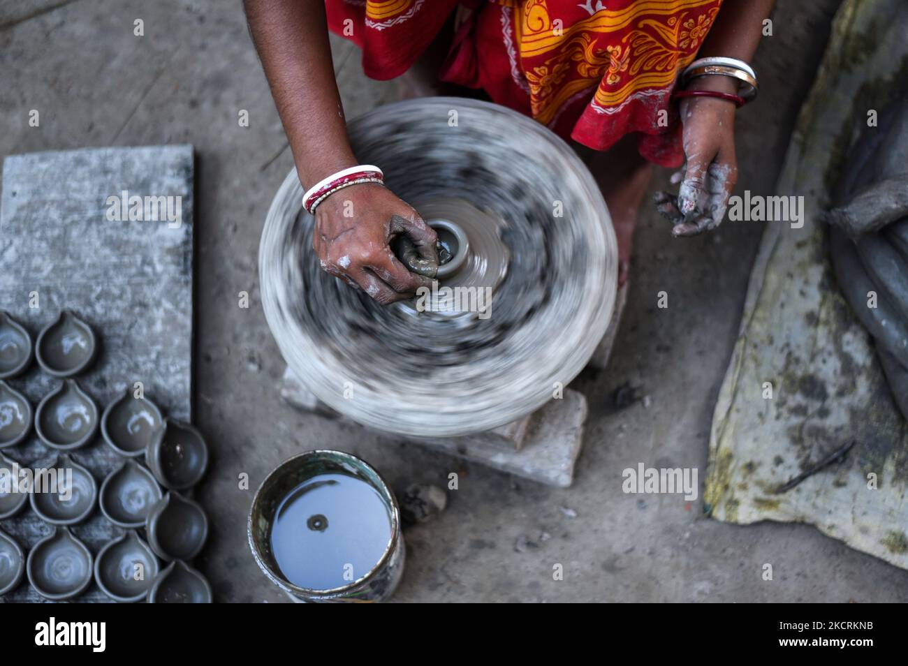 A woman potter makes earthen lamps for the upcoming Diwali festival at ...