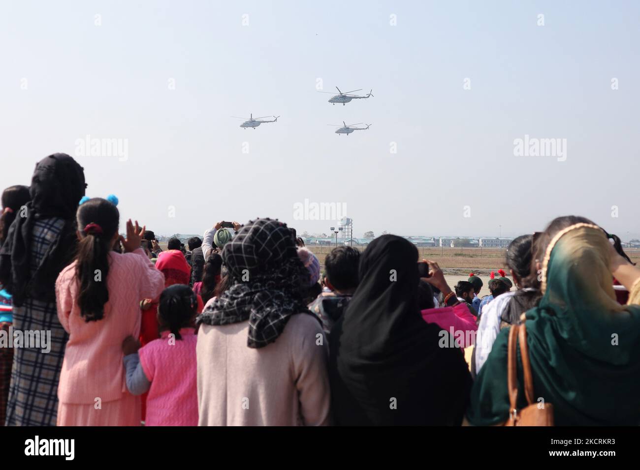 People watch as An Indian army aircraft performs during a re-enactment ...