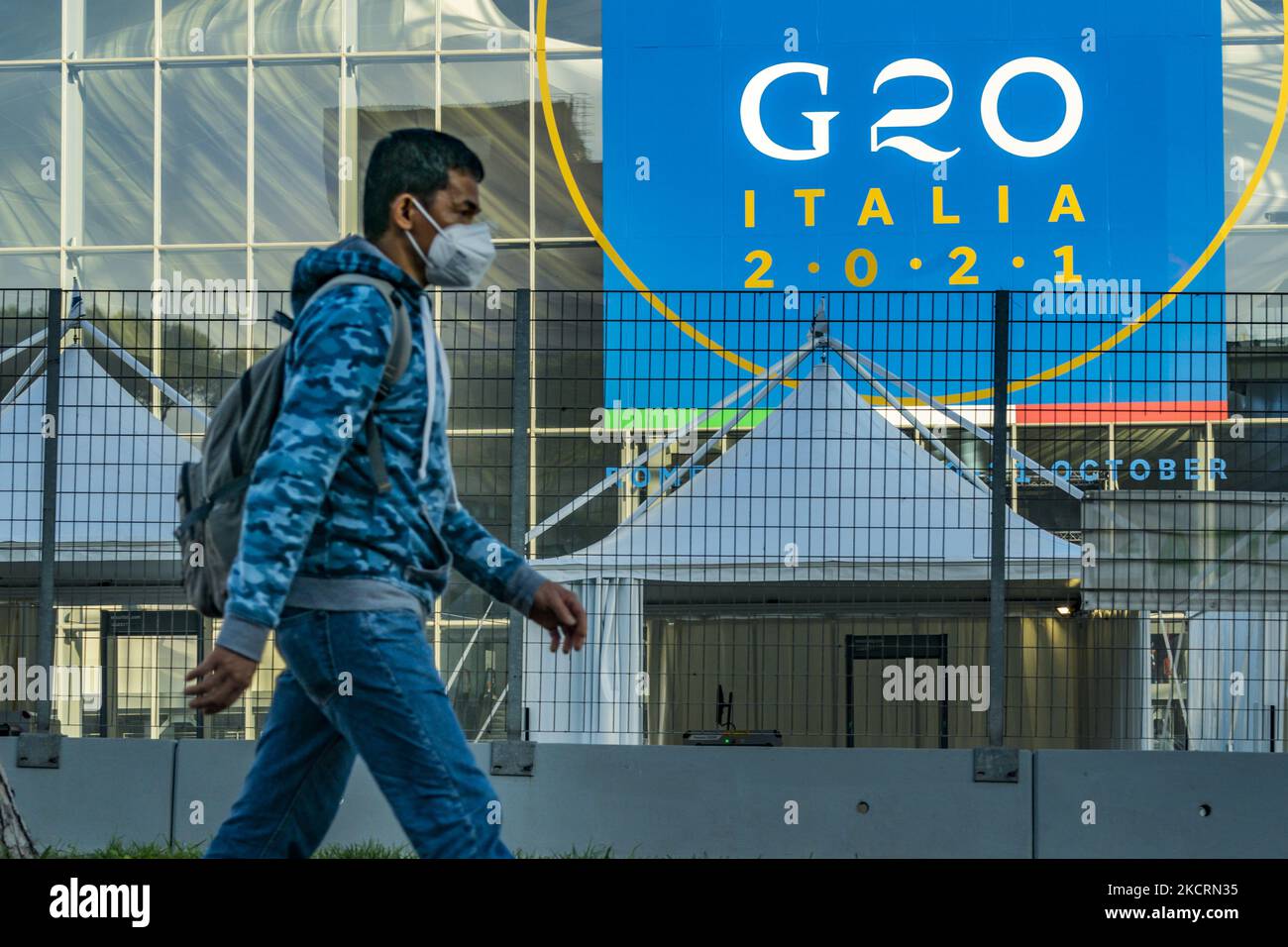 A man walks under a huge banner announcing the G20 Summit in the glass ...