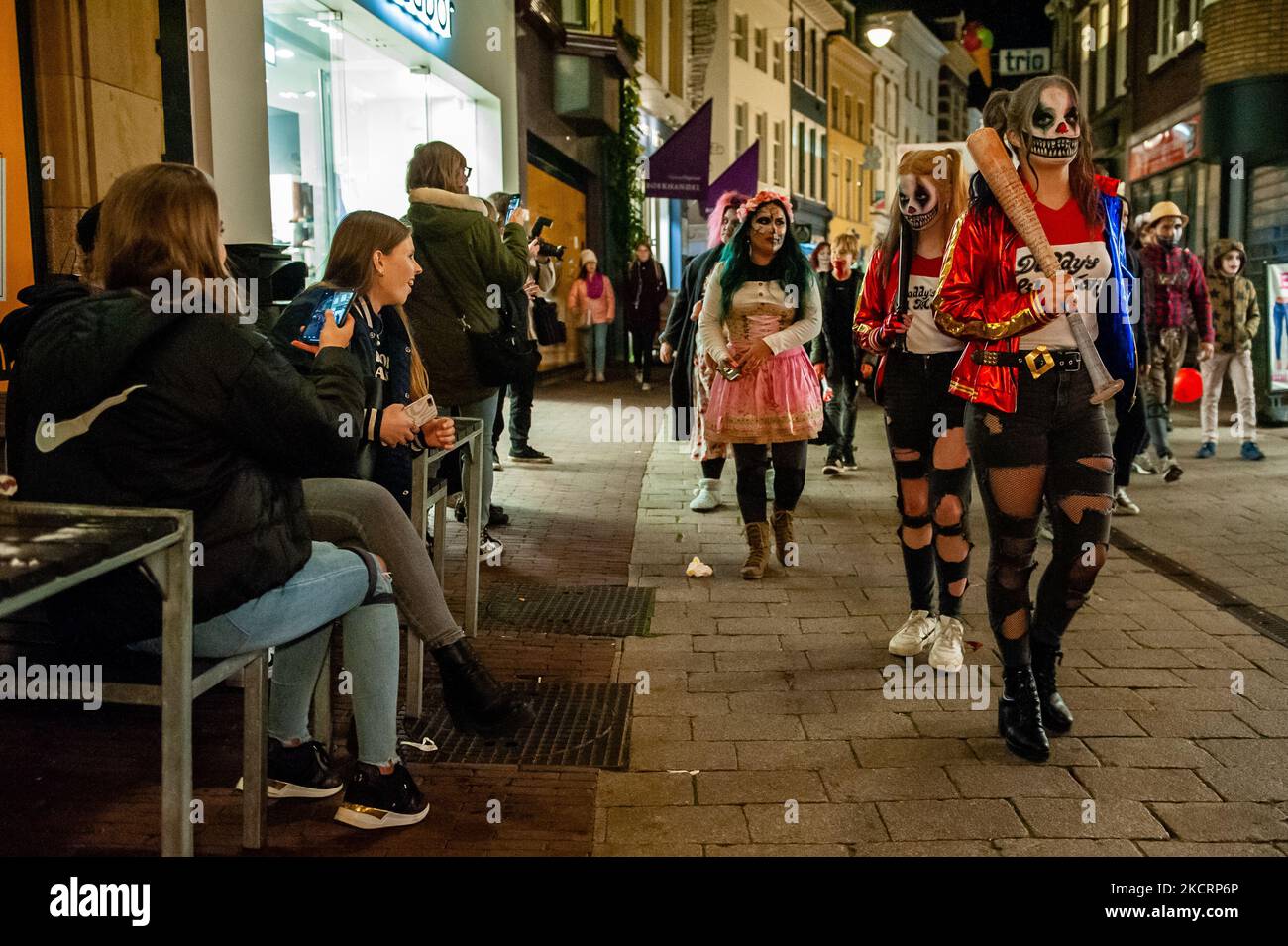 People eating on the terraces are taking photos of the zombies passing ...