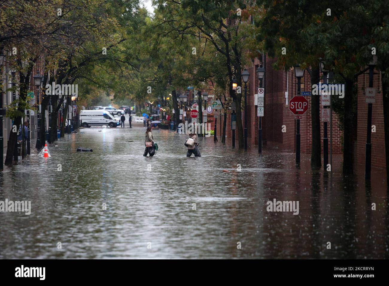 People walk through flood waters in Old Town Alexandria, Virginia on ...