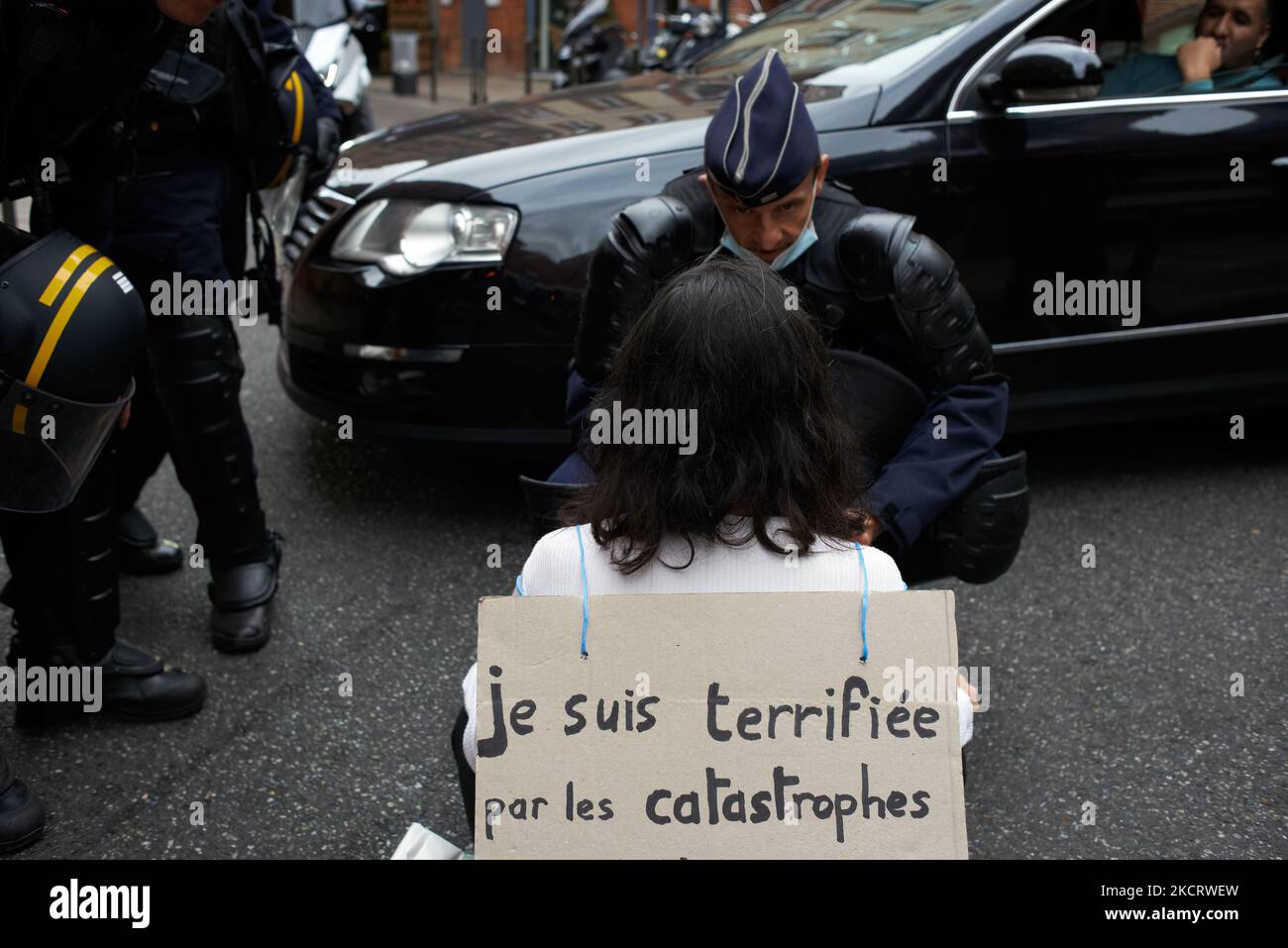 A riot policeman tries to convince a XR activist to quit the road as ...