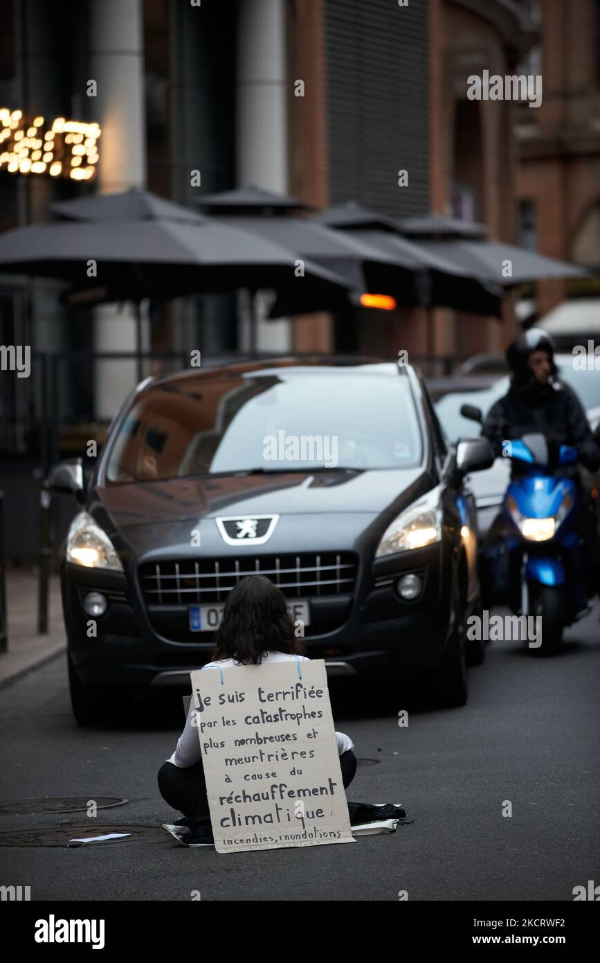 A XR activist block a street in Toulouse. Her placard reads 'I'm ...