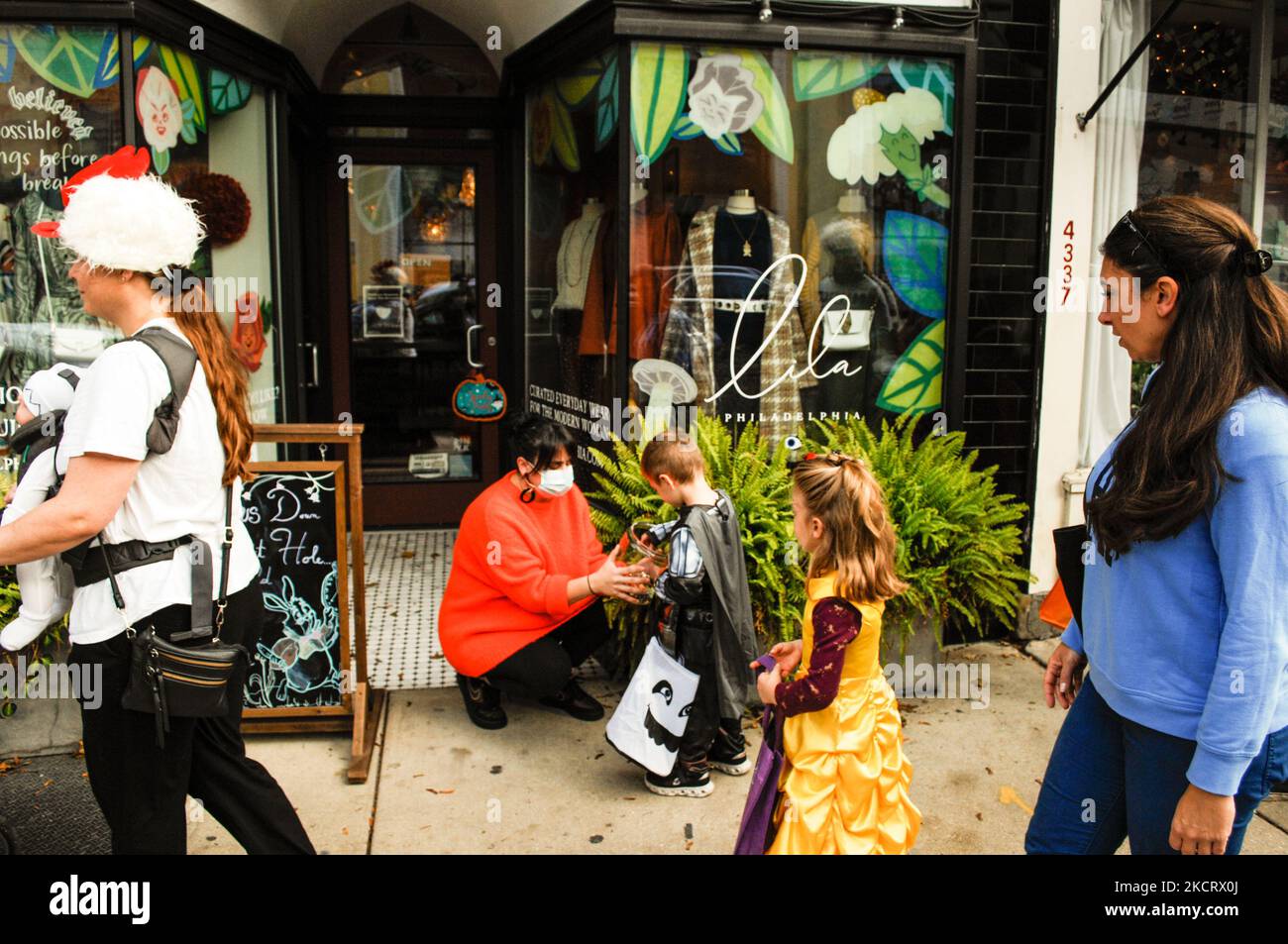Shop owners hand out candy to kids creating a safe trick or treat ...