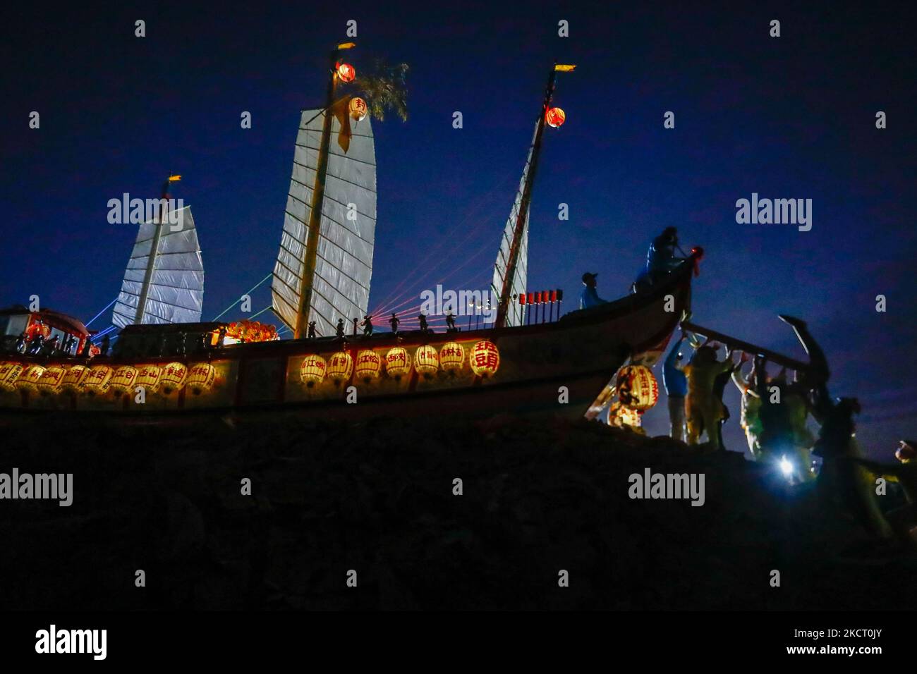 Believers install an anchor before burning a tremendous wooden King ...