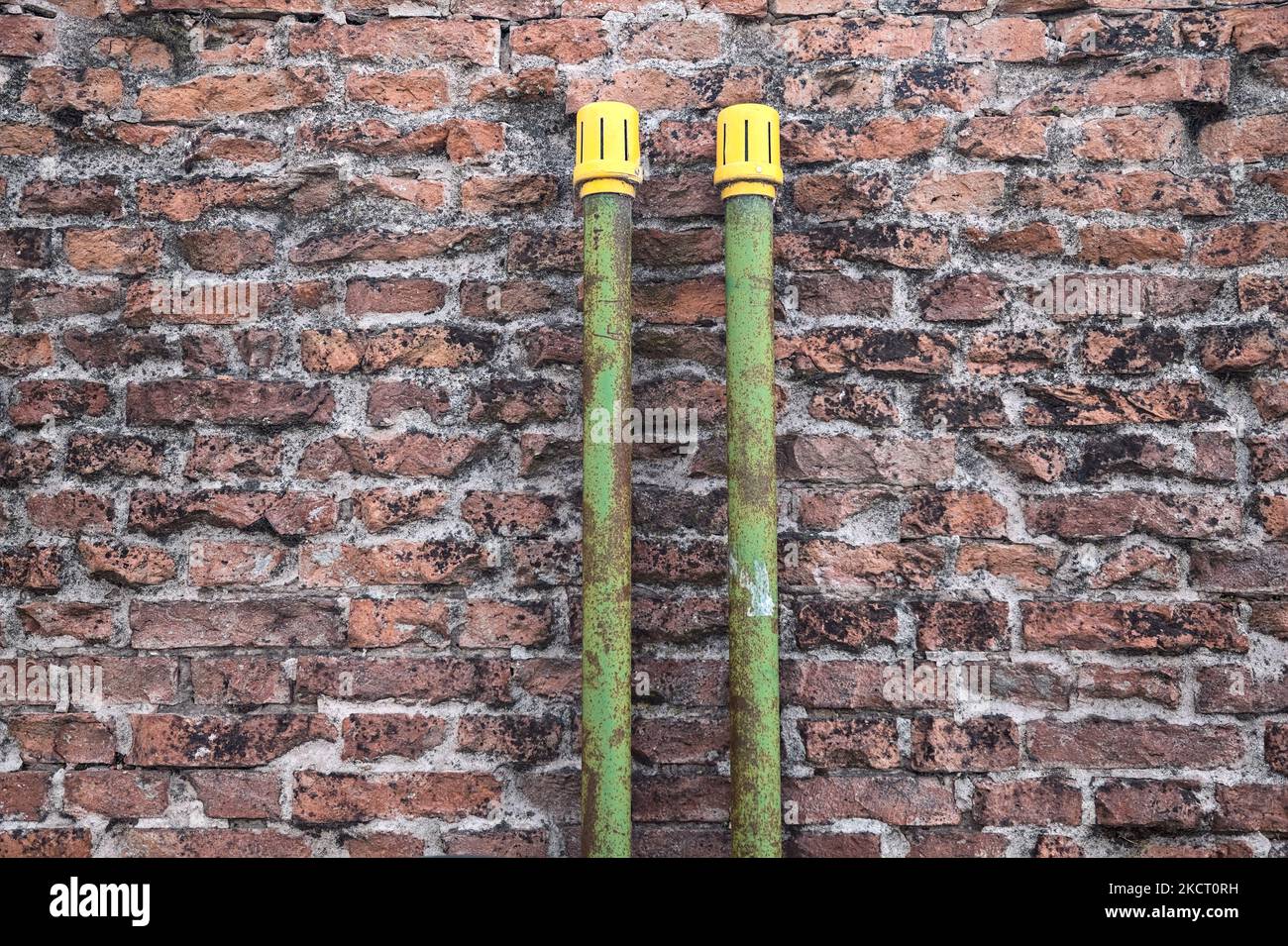 Green pipes on a brick wall Stock Photo - Alamy