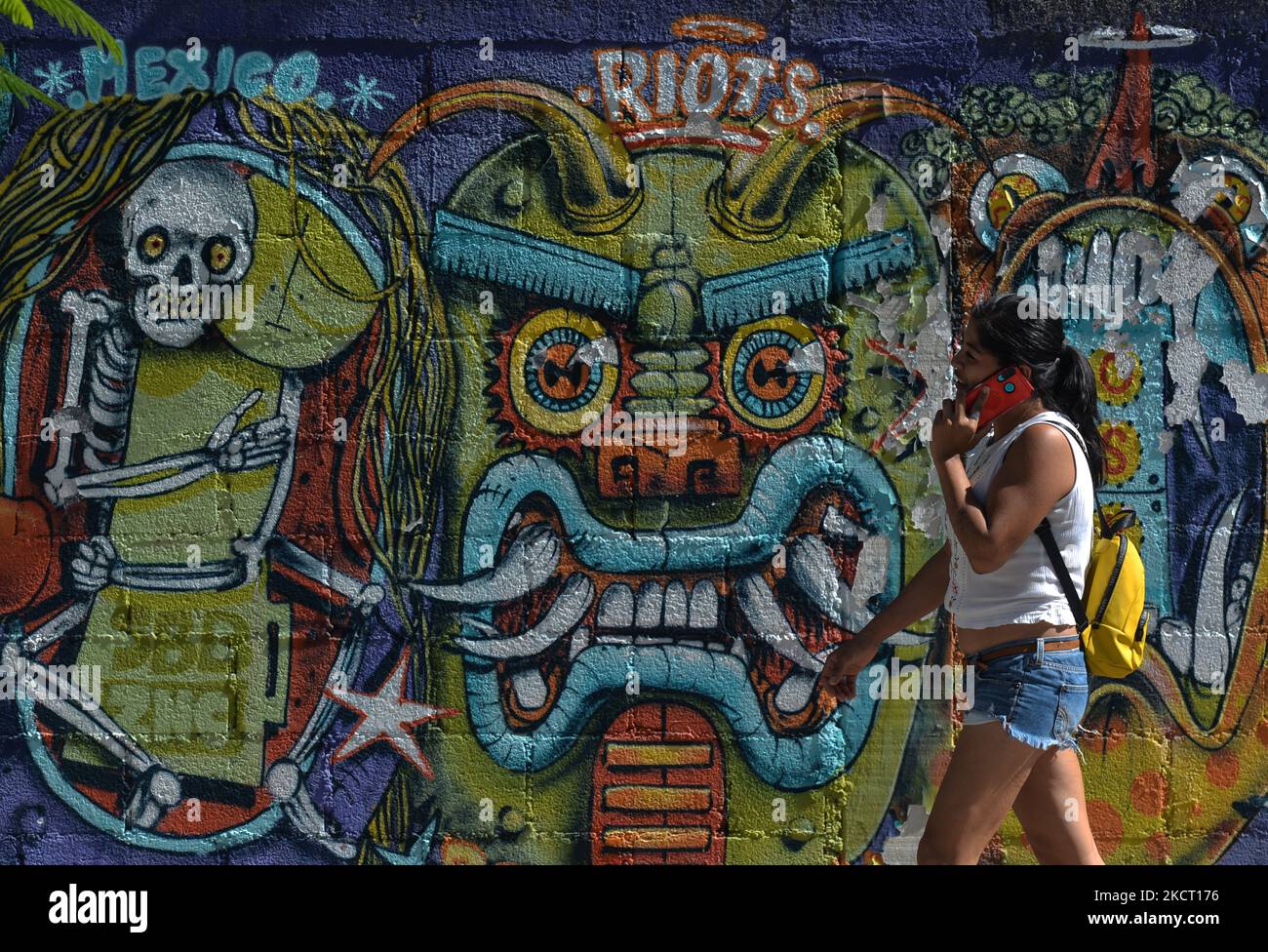 A woman walks past a mural by Riot1394 inspired by the Day of the Dead ...