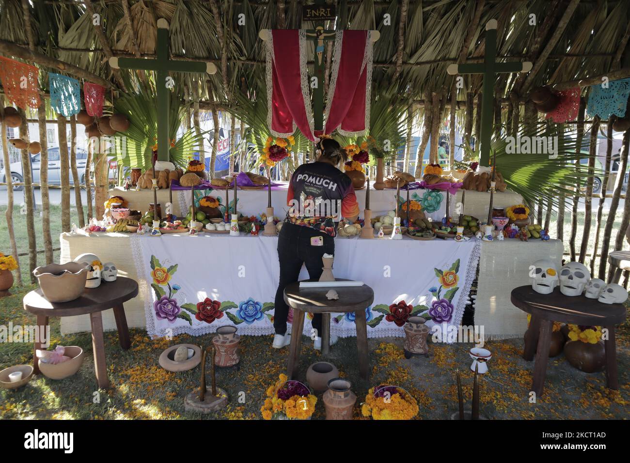A woman places an ofrenda in the indigenous Mayan community of Pomuch ...