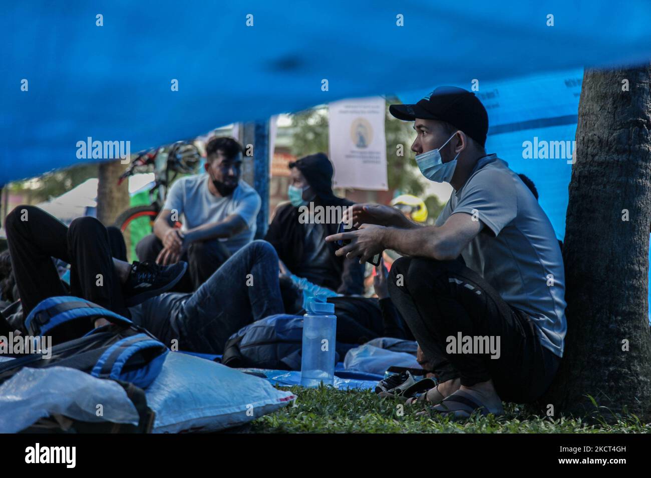 Afghan refugee men living in Indonesia sit in their tent during a ...