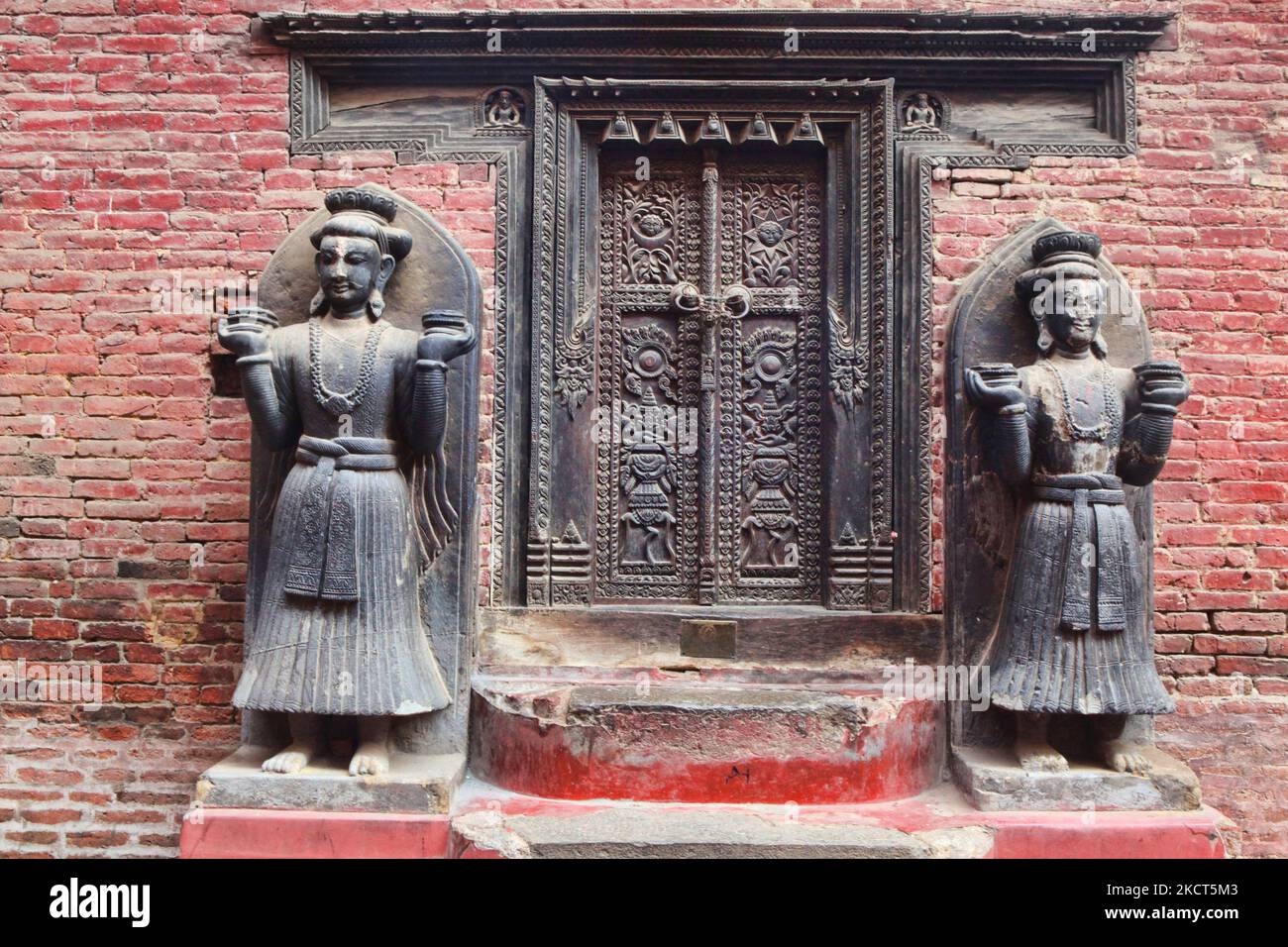 Guardian figures on either side of an intricately carved doorway of the ...