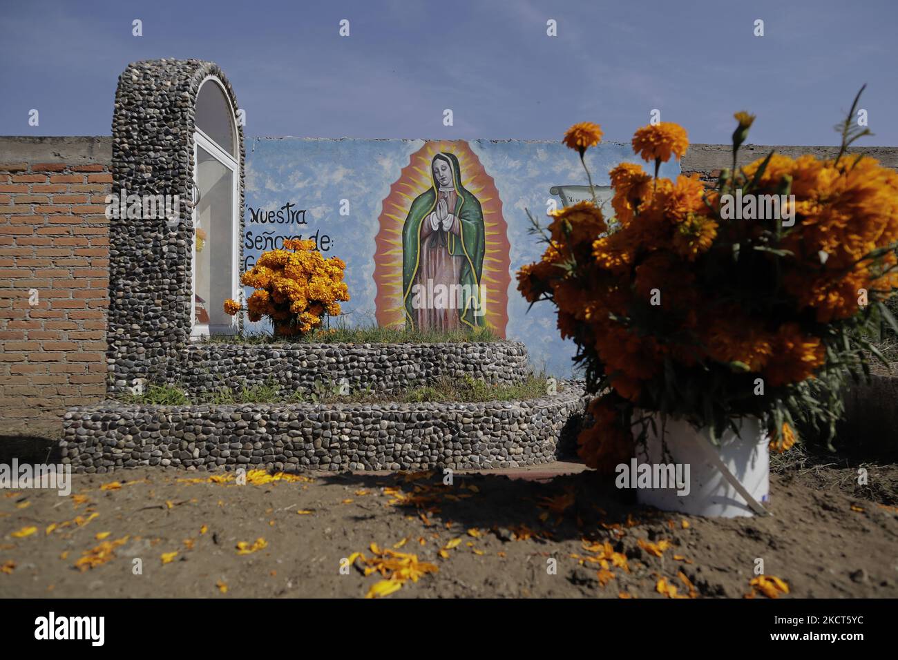 In the background, a mural of the Virgin of Guadalupe inside the ...