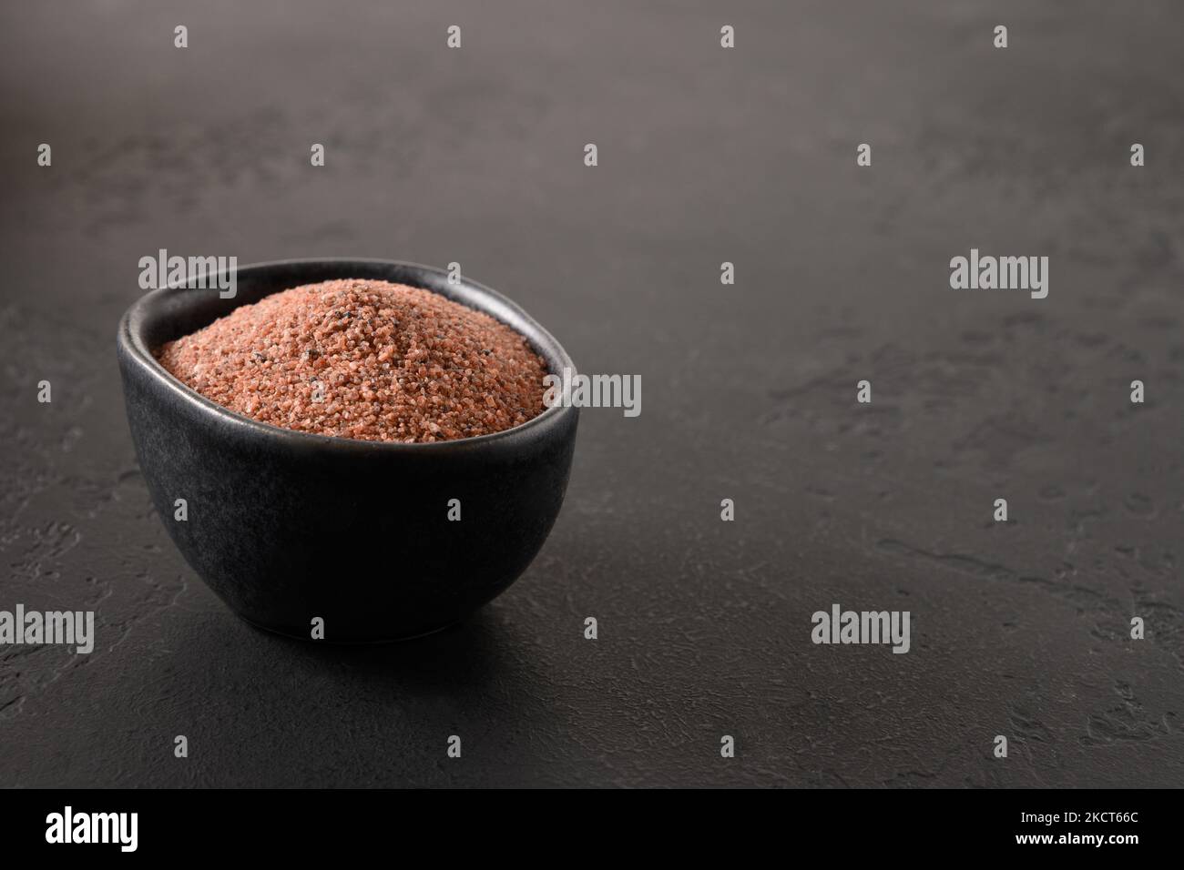 Indian Black salt Kala namak in bowl on black background. Close up ...