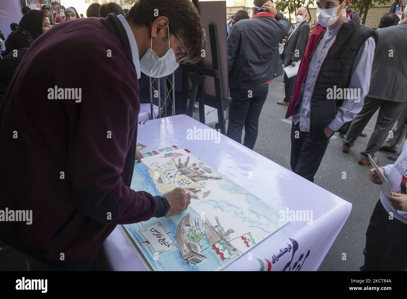 An Iranian cartoonist paints a cartoon of a U.S. Navy warship, during a ...