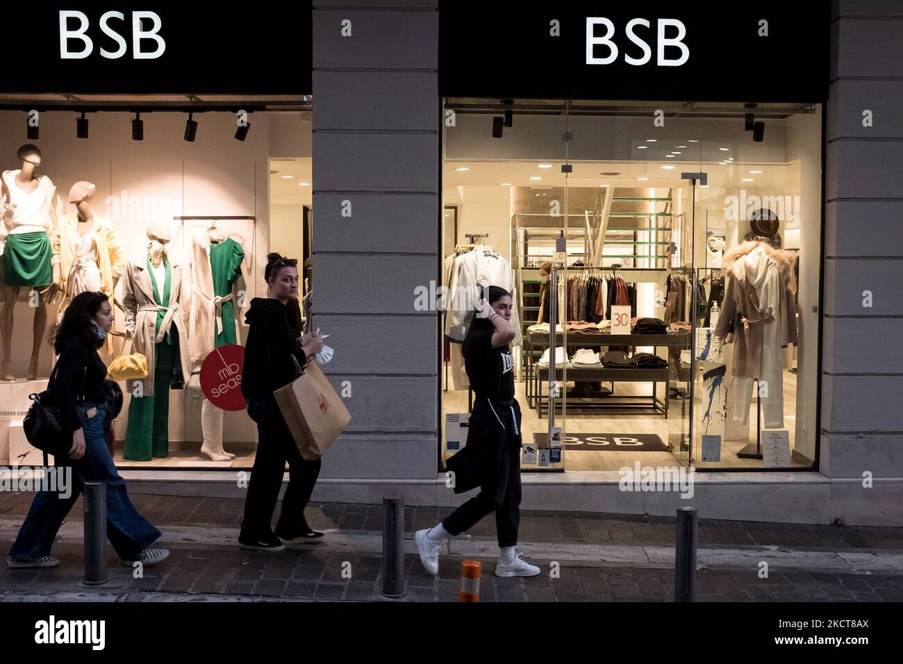 People are passing front of a BSB store at the center of Athens, Greece ...
