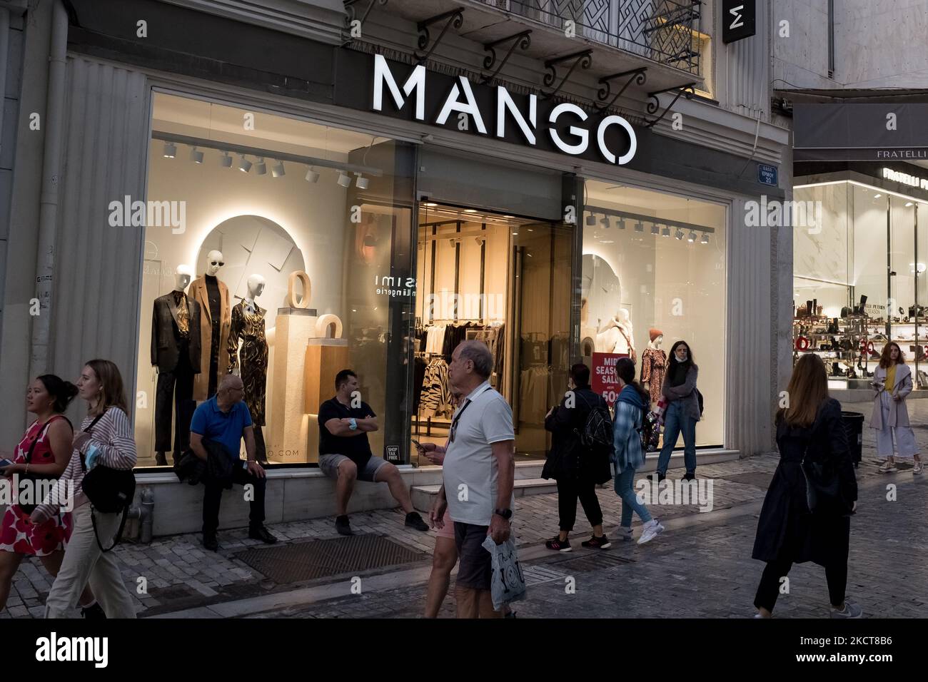 People are passing front of a Mango store at the center of Athens ...