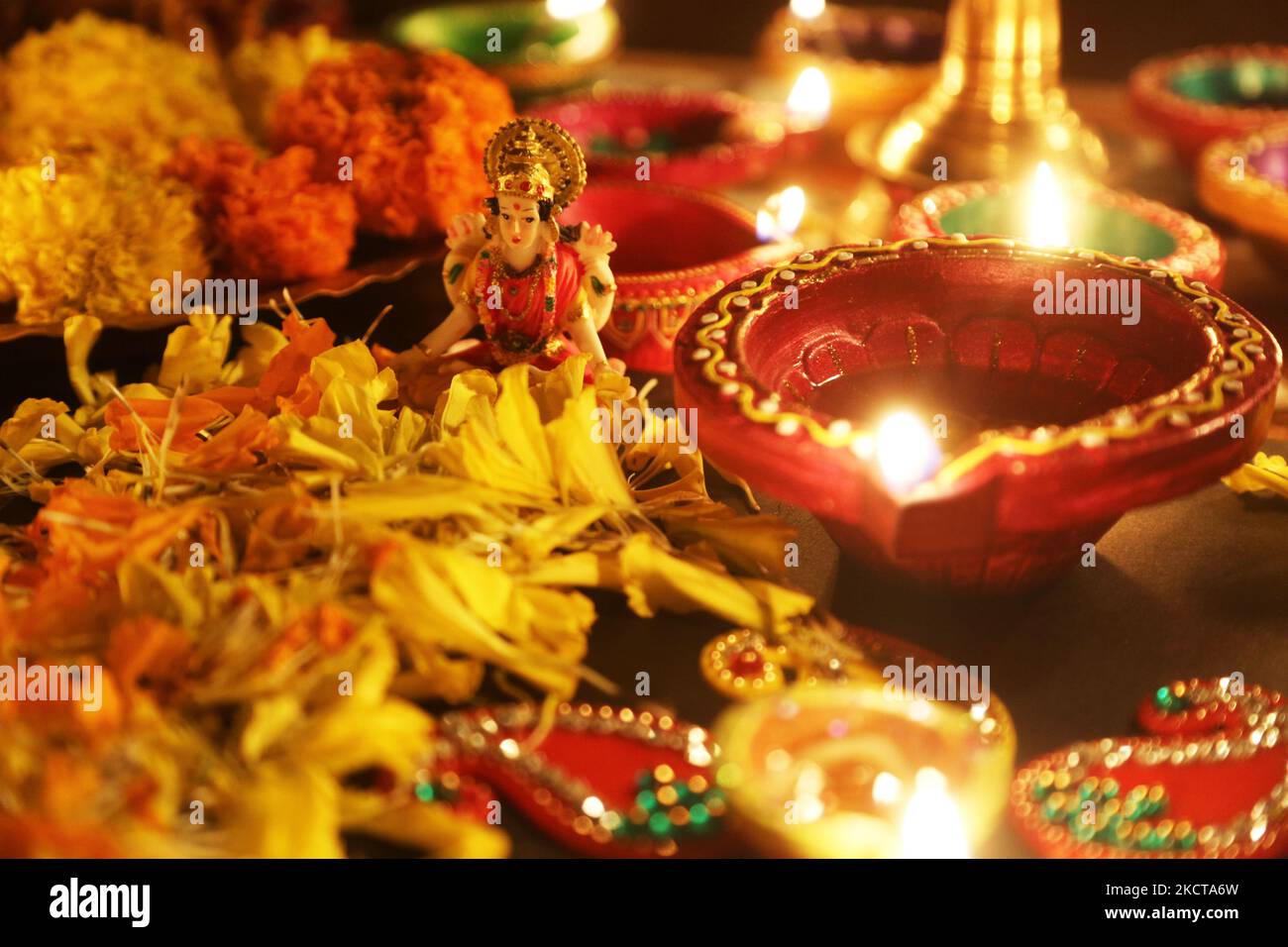 Diyas (small clay lamps) surround an idol of Goddess Lakshmi (Goddess ...
