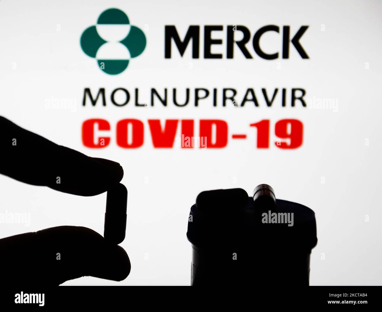 Medicine pill is seen with Merck logo and words 'Molnupiravir' and ...