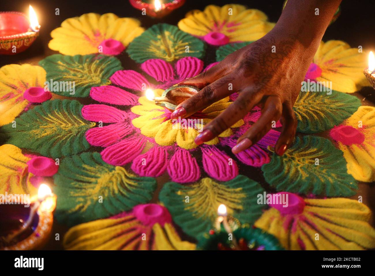 Traditional indian woman lighting diya hi-res stock photography and ...