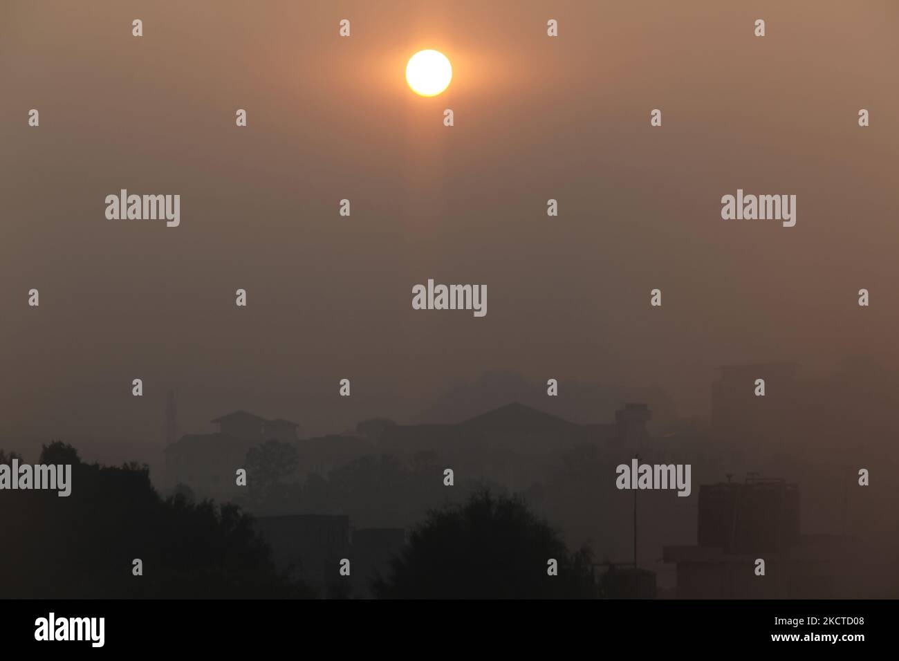 The sun struggles to break through the thick smog over Kathmandu City in the early morning. Poor ...