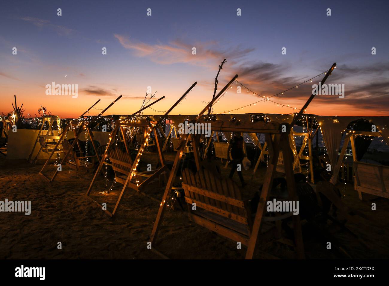 Palestinians sit in a cafe to watch sunset near gaza seaside, on ...