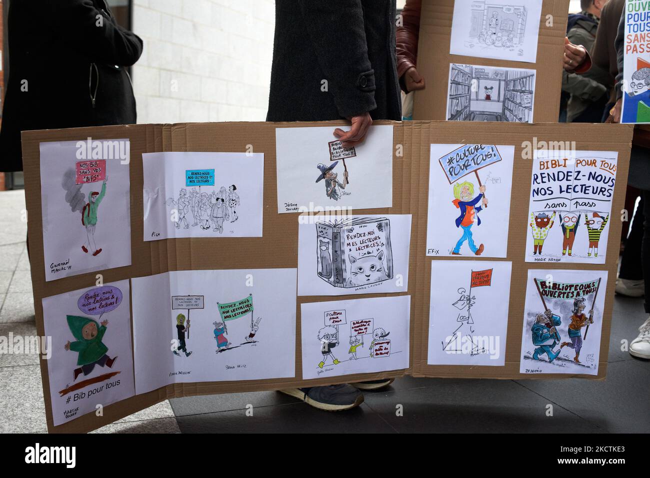 A protestor holds a carboard with several drawings about readers and ...