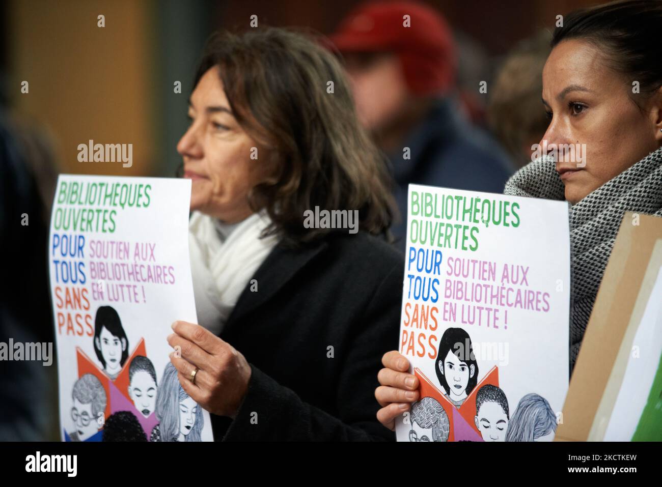 Two librarians in front of the Jose Cabanis library holds placards ...