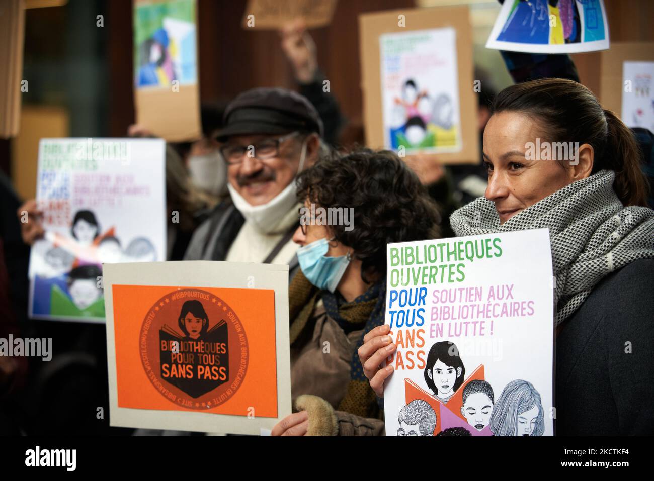 A protester holds a leaflet reading 'Open libraries for all without ...