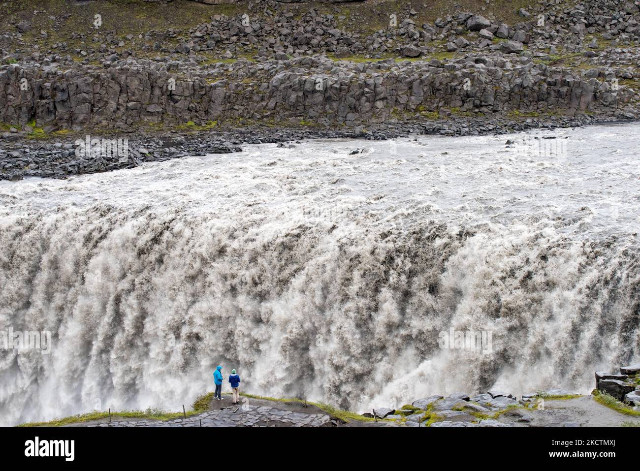 Tourists admire Dettifoss waterfall on a rainy day. Dettifoss is the ...