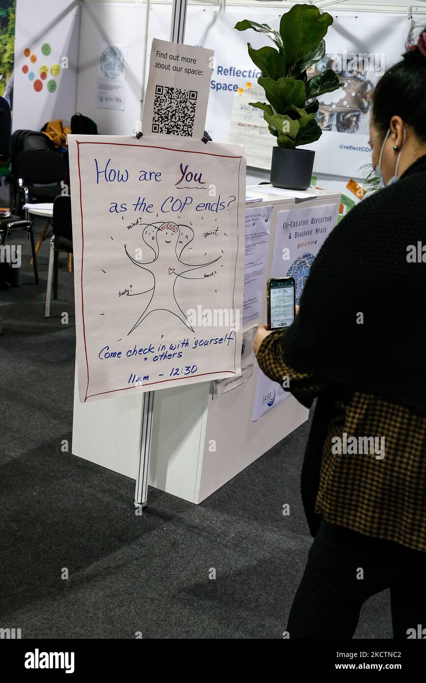 A participant takes of photo of a poster as exhibitors and participants ...