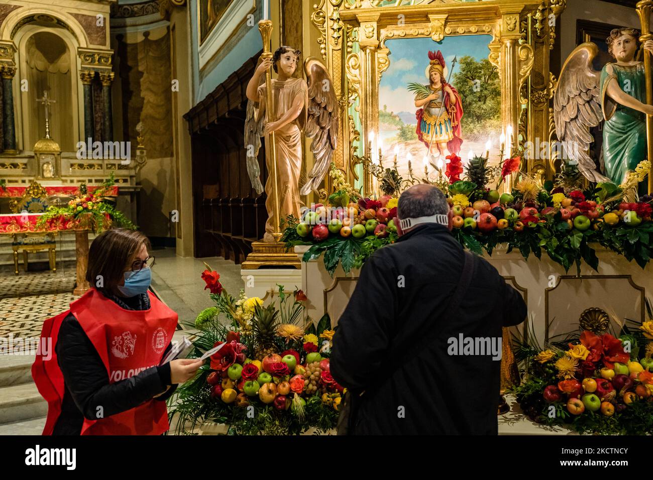 A faithful makes an offering in front of the icon of San Trifone ...