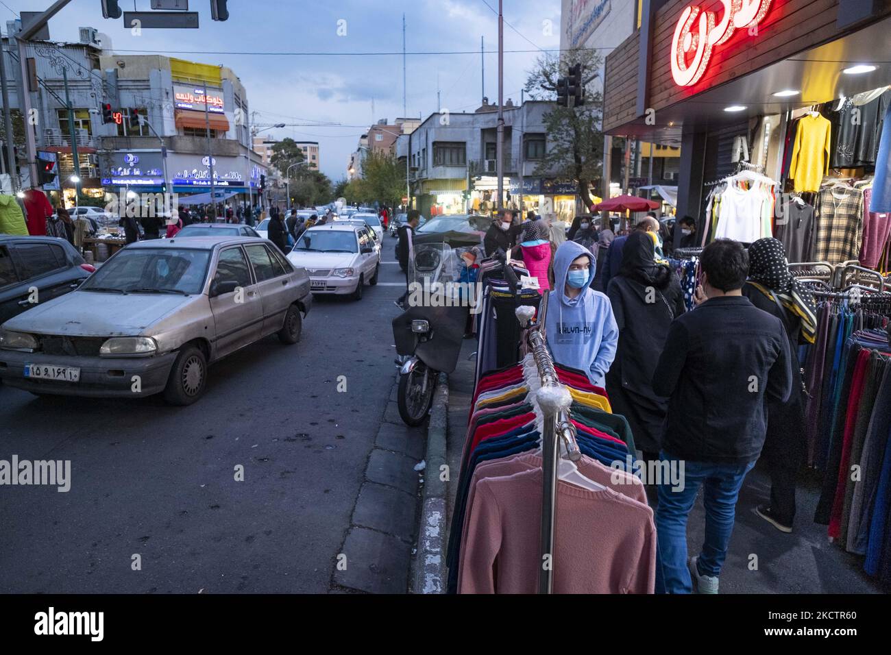 An Iranian young man looks on while standing next to clothes placed on ...
